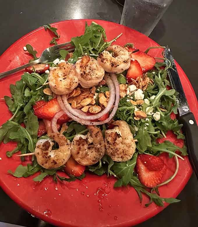 Plump blackened shrimp crown a bed of fresh greens and strawberries in this flavor-packed salad creation.