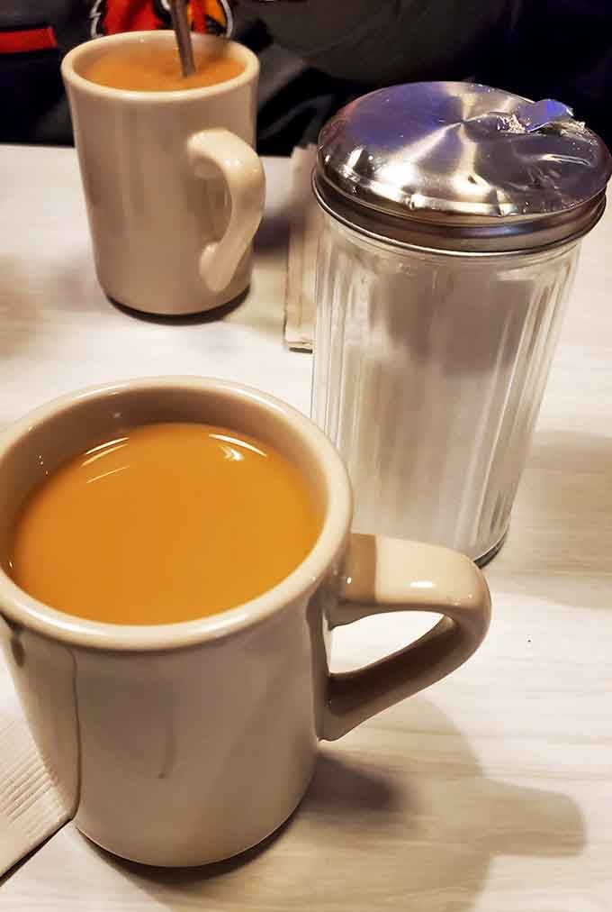 Hot coffee in classic diner mugs with a vintage sugar dispenser&mdash;some traditions never go out of style for good reason.