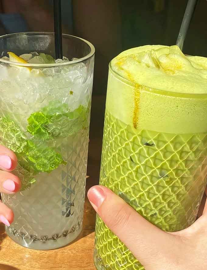 Refreshing matcha green tea and lime soda in textured glasses offer the perfect literary companion for your reading session.