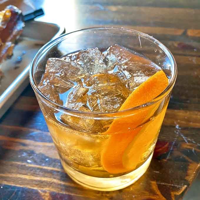 An old fashioned with a citrus twist pairs beautifully with barbecue, proving sophistication and sauce can coexist peacefully.