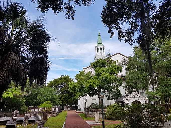 The church steeple rises through ancient oaks, creating a postcard view that hasn't changed in generations.