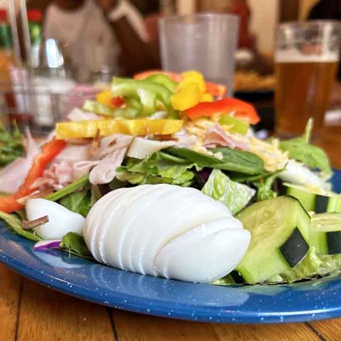 Fresh greens, sliced egg, colorful peppers, and real ingredients make this salad worth the scenic drive alone.