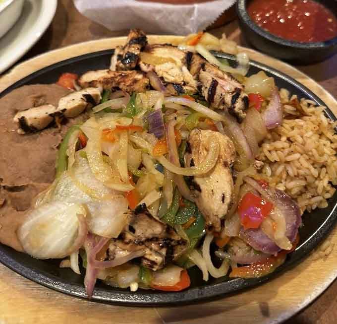 Sizzling chicken fajitas arrive at your table like a delicious announcement that dinner has officially begun.