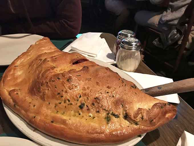 A calzone this perfectly golden and puffy could make a grown adult weep tears of pure carbohydrate joy.