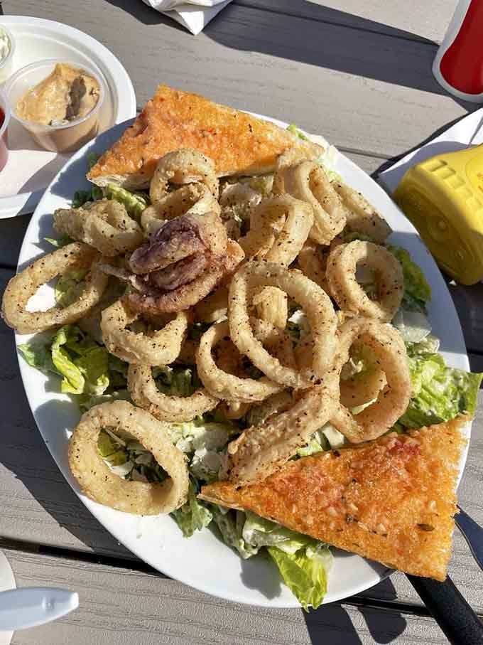 Calamari rings stacked on Caesar salad create a tower of fried perfection that would make architects jealous.