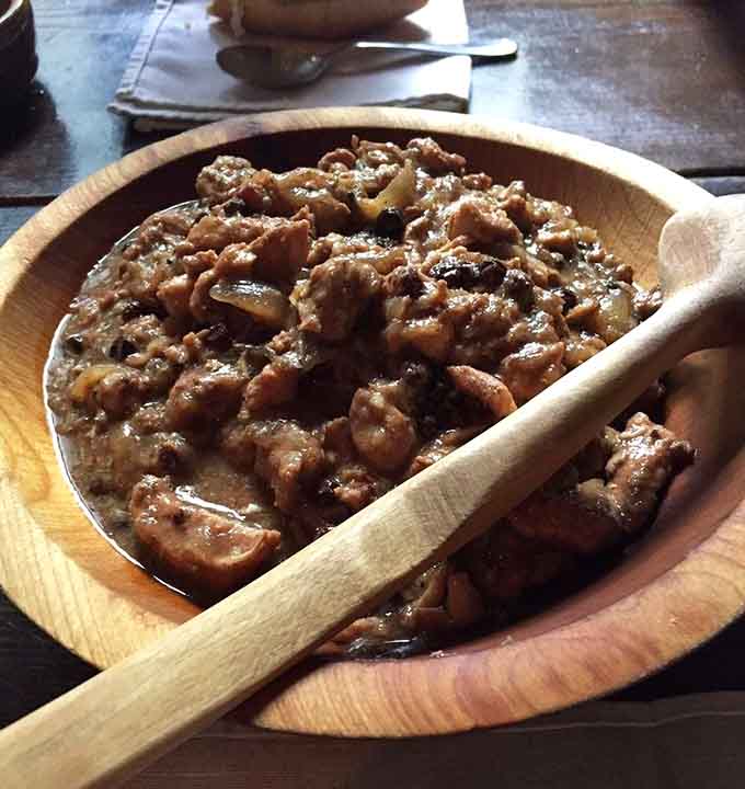 This hearty dish in a wooden bowl is comfort food that transcends time, forks optional but unnecessary.