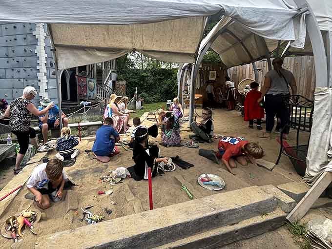 Kids sprawl on the ground learning medieval crafts, their concentration rivaling any knight preparing for tournament battle.