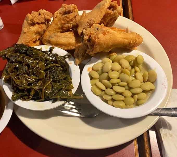Fried chicken wings paired with collard greens and lima beans, bringing soul food comfort to every single bite.