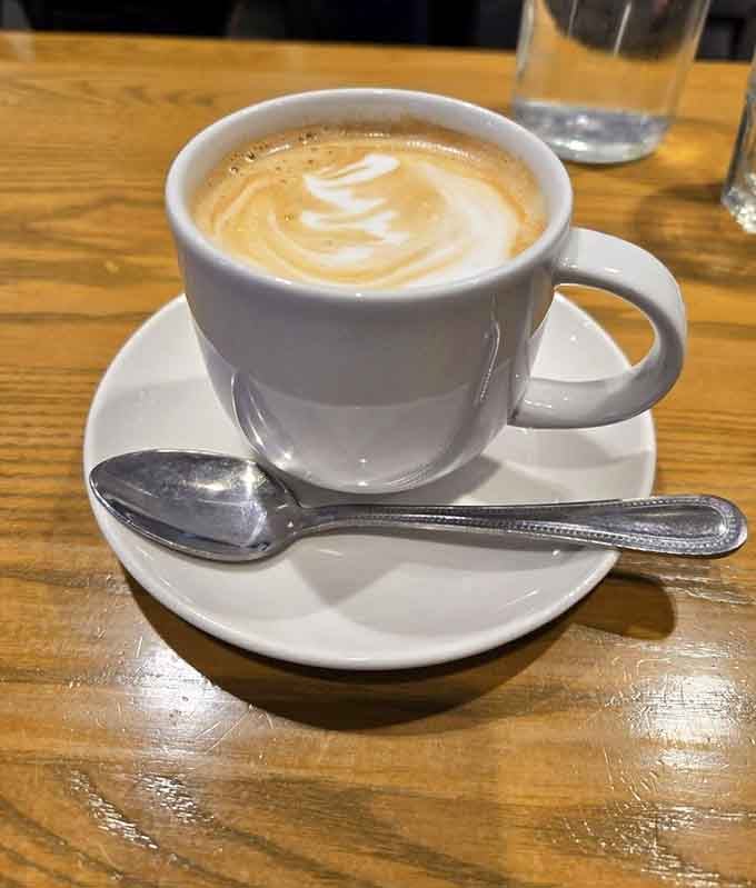 That latte art swirl is almost too pretty to drink, though your caffeine-deprived brain will override any aesthetic hesitation.