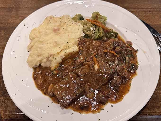 The pot roast arrives looking like comfort food got a PhD in deliciousness and decided to overachieve.
