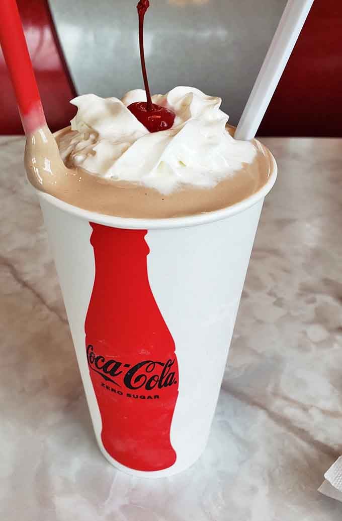 That chocolate shake crowned with whipped cream and a cherry looks thick enough to require some serious straw determination.