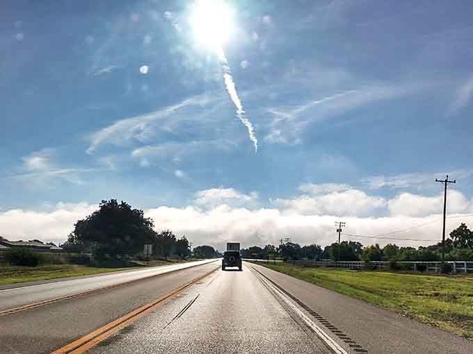 Sunshine breaks through clouds like a Hollywood spotlight, illuminating the highway ahead with dramatic flair worthy of Spielberg.