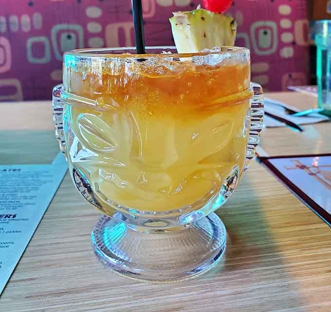 This mai tai in a tiki glass garnished with pineapple is basically vacation in drinkable form, umbrella not required.