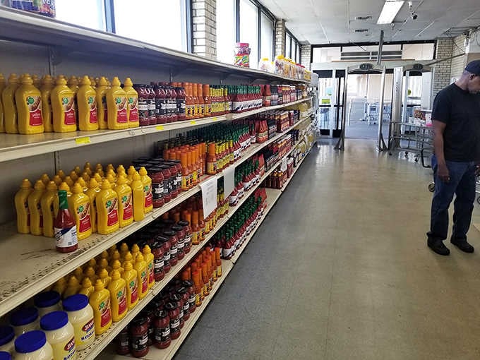 Rows of golden hot sauce bottles gleam like liquid sunshine, each one promising a different level of delicious heat.