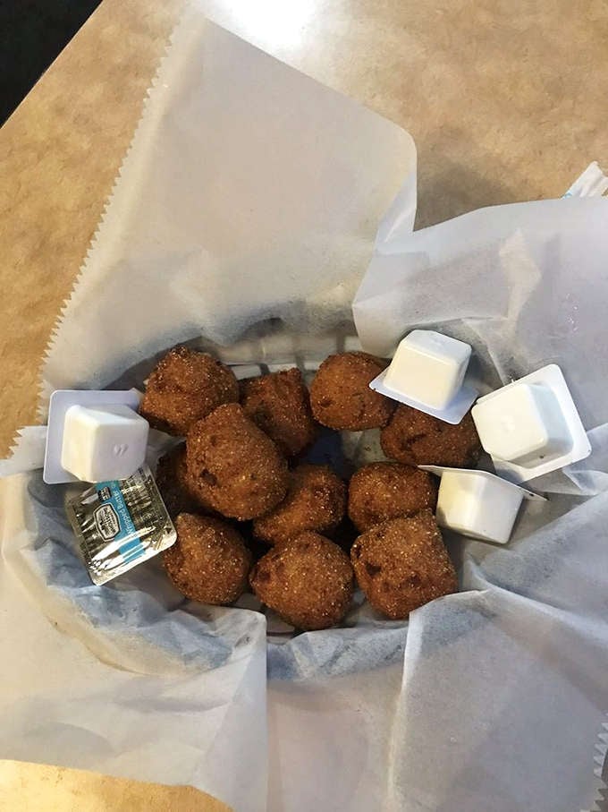 Hush puppies emerge from the kitchen like little golden treasures, crispy outside and impossibly tender within each bite.