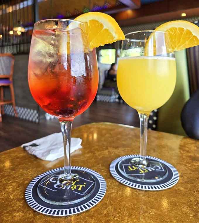 Colorful drinks that look like liquid sunshine decided to throw a party in stemware with fancy coasters.