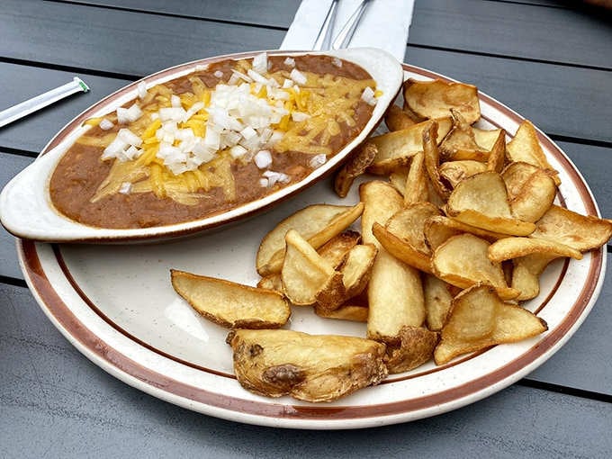 Chili cheese fries topped with enough toppings to require structural engineering and serious appetite commitment.