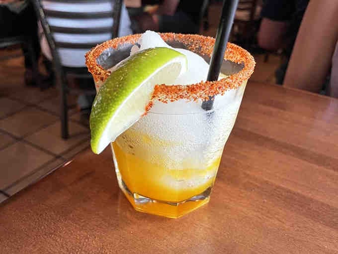 A mango frozen margarita with a spicy rim that's basically summer vacation in a glass.