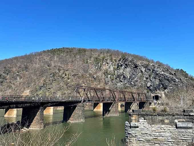 The railroad tunnel entrance stands like a portal to another era, still serving trains over a century later.