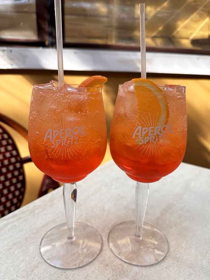 Two Aperol Spritzes catching the light like liquid sunshine, because sometimes you need bubbles with your carbs.