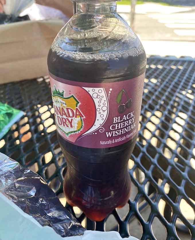Black cherry soda on a metal table outside, because sometimes the simple pleasures are the best ones available.