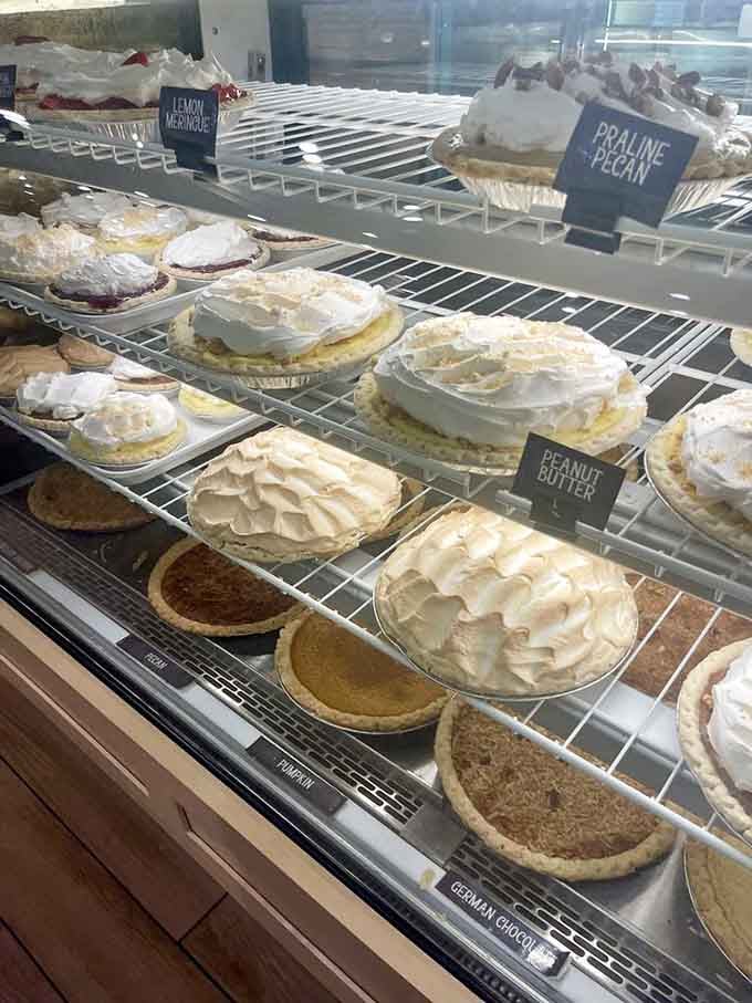 A pie case that looks like heaven's dessert display, featuring everything from peanut butter cream to classic fruit varieties.
