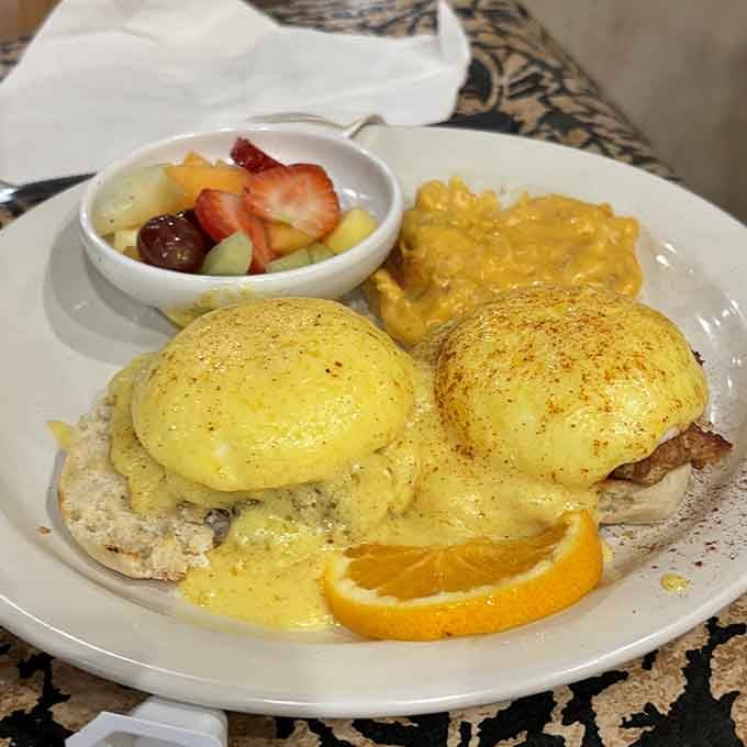 Eggs Benedict done right, with hollandaise that flows like liquid gold over perfectly poached eggs and fresh fruit.