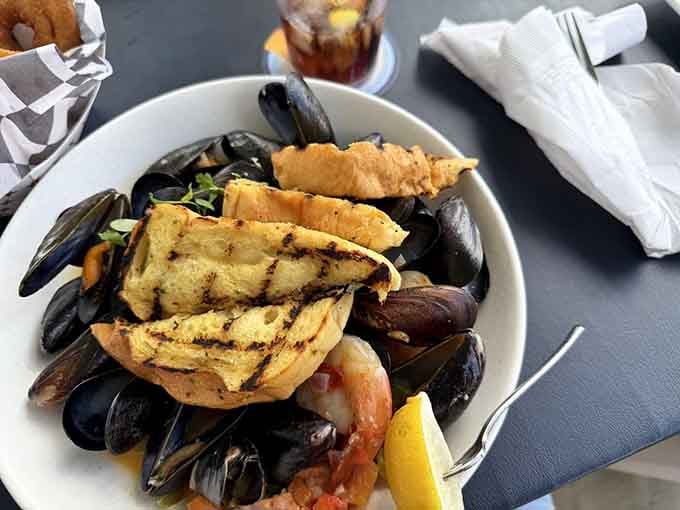 Mussels piled high with grilled bread for soaking up every drop of that garlicky, wine-infused broth.