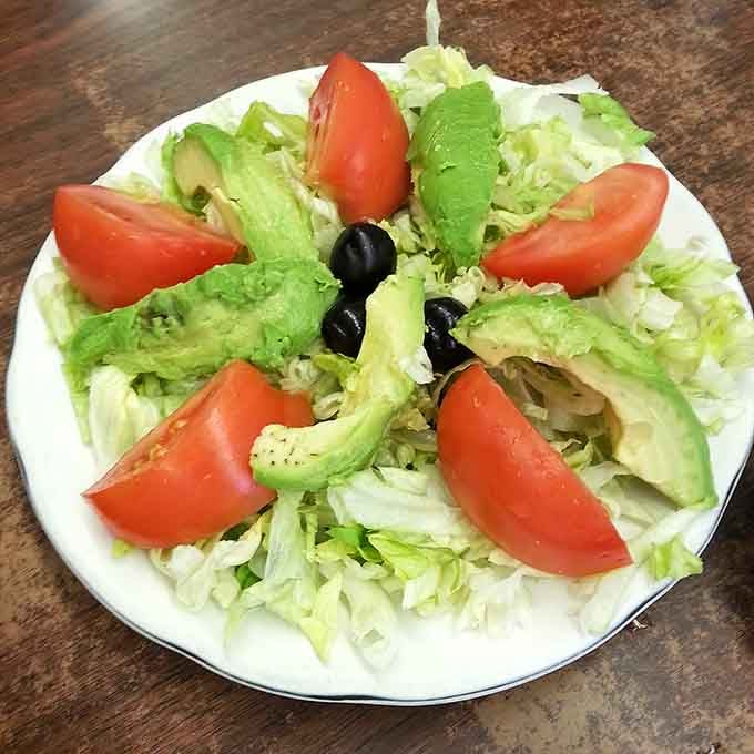 Fresh lettuce, ripe tomatoes, creamy avocado, and olives create a salad that's almost too pretty to eat. Almost.
