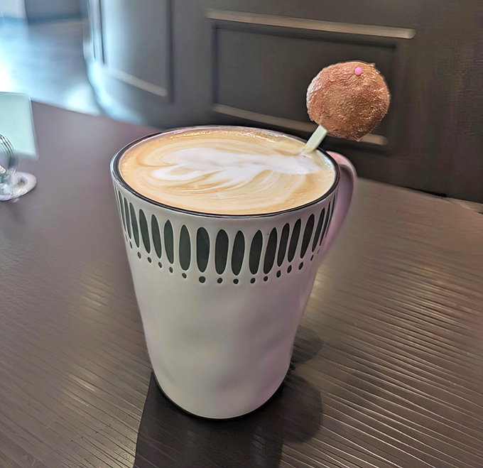 A latte topped with a mini donut, because someone finally asked "why not?" and the answer was absolutely brilliant.