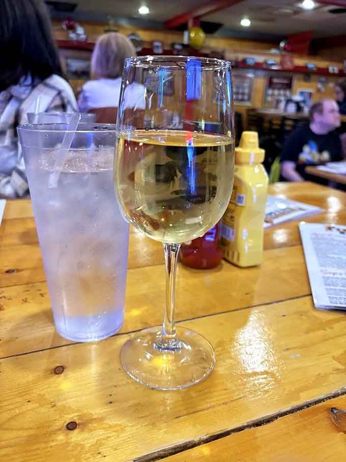 Wine and water sitting together on a wooden table, the yin and yang of beverage choices.