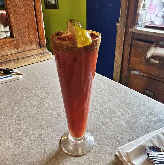 That tall glass of Bloody Mary with its pickle garnish looks like Sunday brunch decided to get fancy and fun simultaneously.