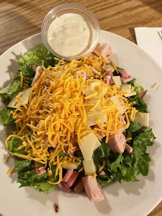 A chef salad piled high with ham, cheese, and enough toppings to qualify as a full meal experience.
