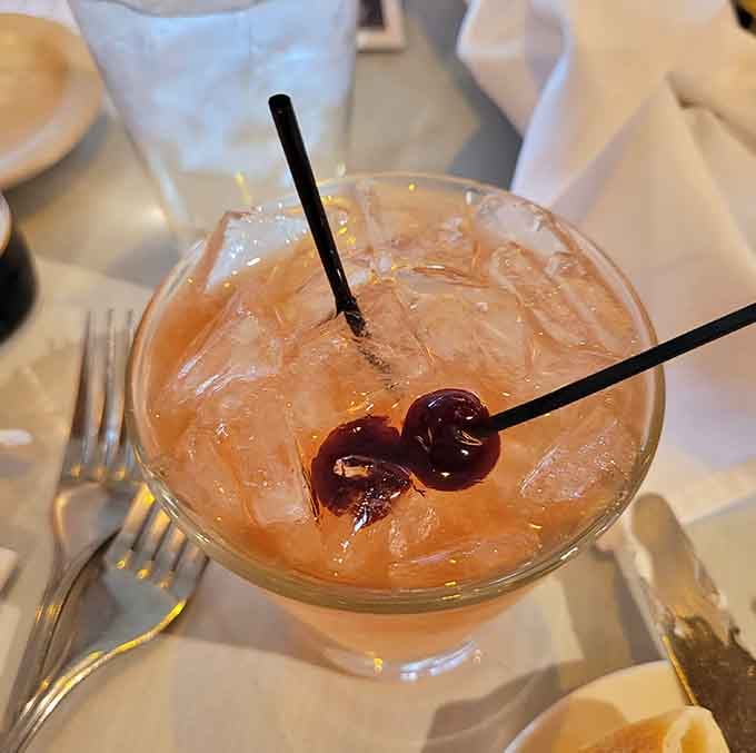 A cocktail garnished with cherries, because even in a haunted restaurant, you deserve something sweet and refreshing.