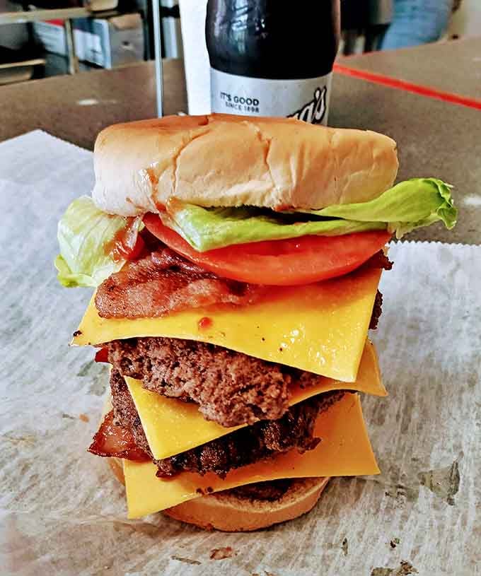 The Triple Bacon Cheeseburger towers like a delicious Jenga game you actually want to collapse into.