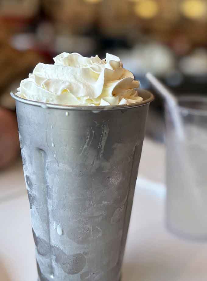 A proper milkshake in a metal cup with whipped cream proves some traditions should never be modernized or messed with.