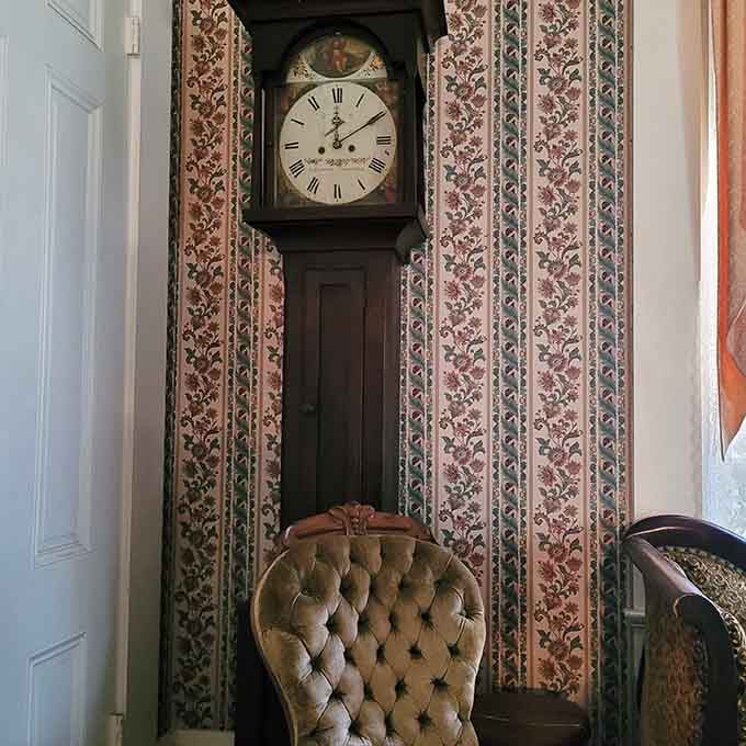 A grandfather clock stands sentinel, marking time in a house where past and present seem to blur together uncomfortably.