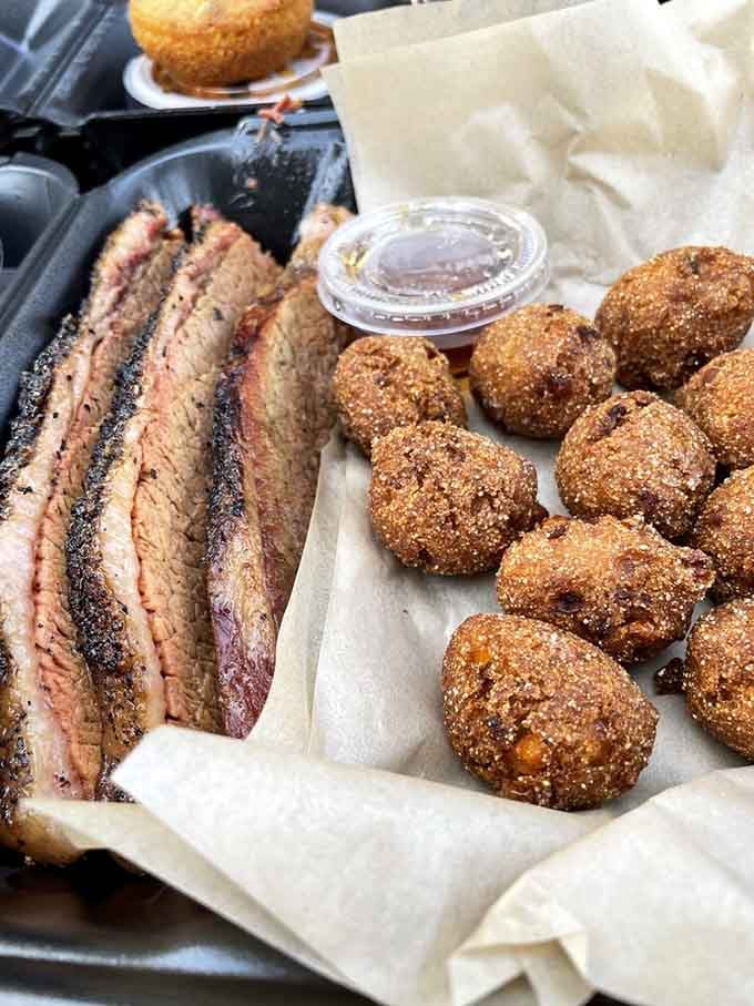 Sliced brisket with a smoke ring that deep deserves its own standing ovation, alongside those golden hush puppies.