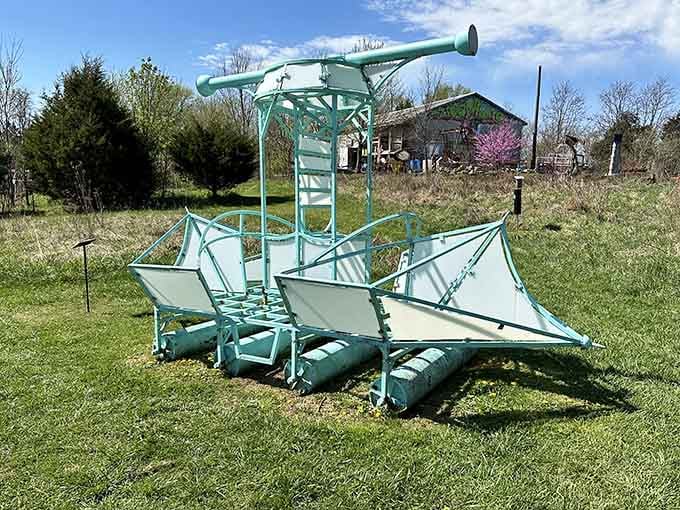 A turquoise boat sculpture sits landlocked in the grass, ready to sail across fields instead of water.