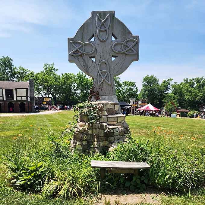 A Celtic cross monument stands as a beautiful centerpiece, adding authentic historical atmosphere to the sprawling Renaissance village landscape.