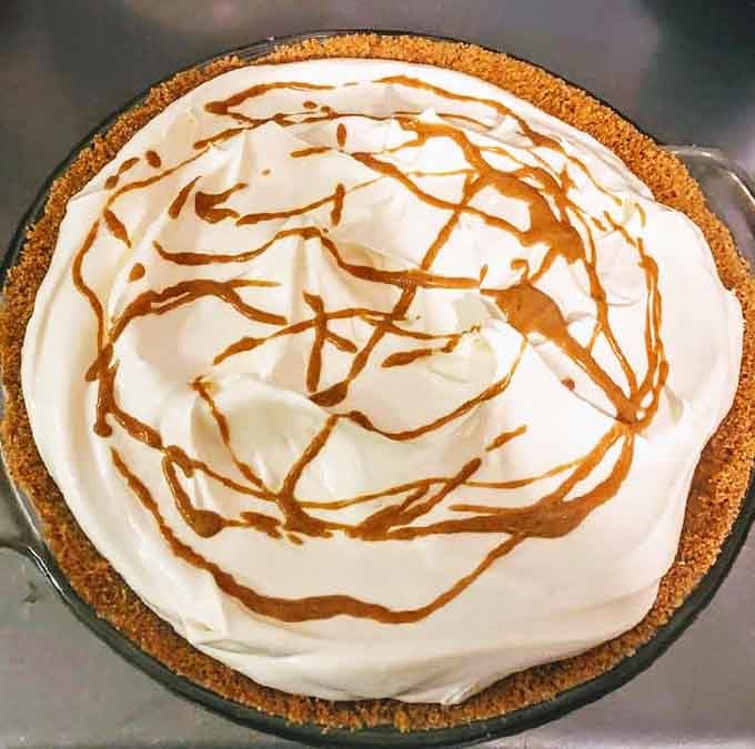 Peanut butter pie topped with whipped cream and caramel drizzle, because life's too short to skip dessert ever again.