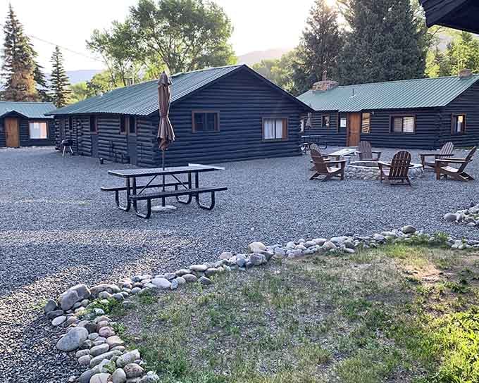 These dark log cabins and picnic tables offer front-row seats to mountain views that cost absolutely nothing extra.