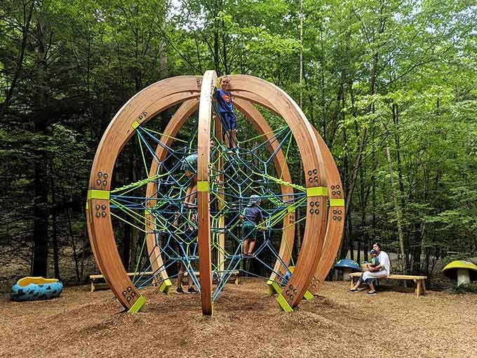 This spherical climbing structure challenges kids while parents enjoy a well-deserved bench break nearby with coffee.