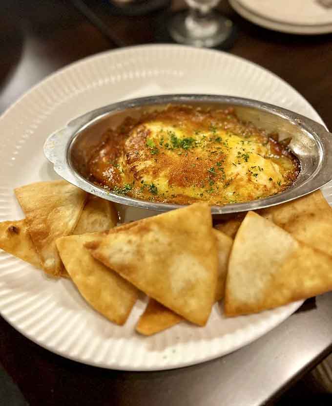Bubbling crab dip with crispy pita chips arranged like soldiers ready for delicious duty, resistance is futile.
