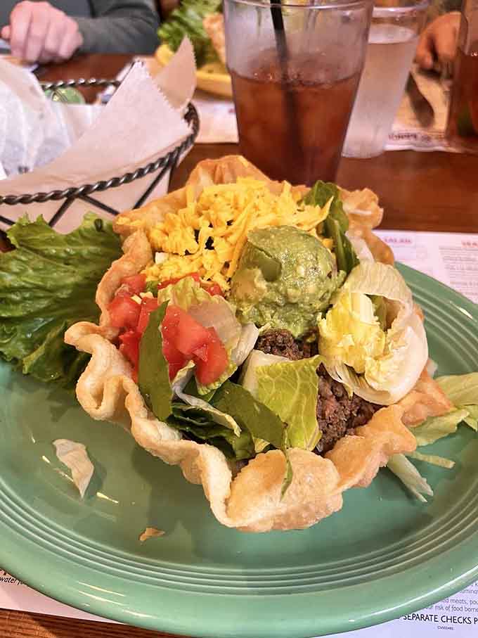 A crispy taco salad tower loaded with everything good in life, served in an edible bowl of pure genius.