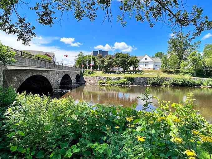 Stone arches frame the river perfectly, creating natural beauty spots where wildflowers bloom freely along the peaceful waterway each summer.