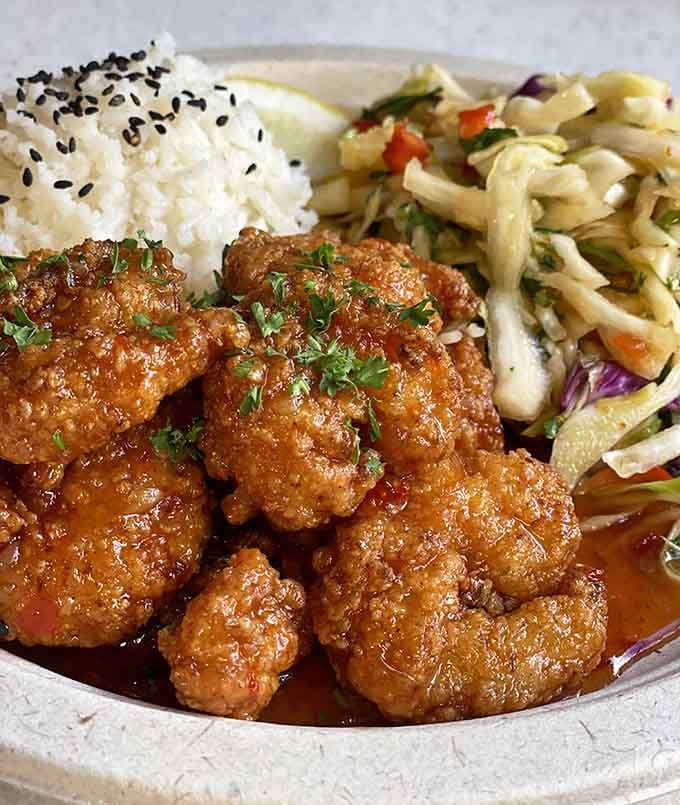 Sweet shrimp glazed to perfection, served with rice and slaw for a flavor journey worth taking.