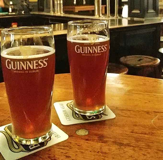Two pints of draft beer sitting pretty on the bar, ready to make your day better than it was.