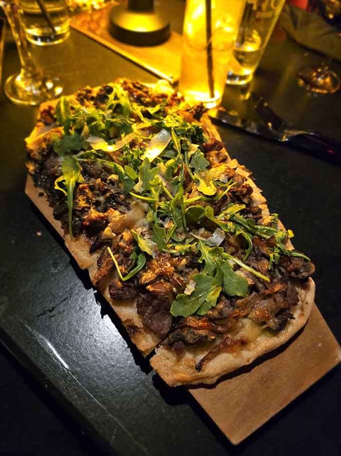 Flatbread topped with mushrooms and fresh arugula proves that gothic restaurants can do sophisticated flavors beautifully.