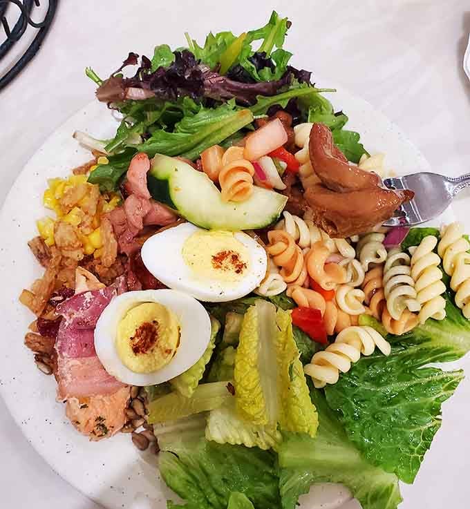 A salad plate proving you're making healthy choices before returning for round three of the really good stuff nearby.